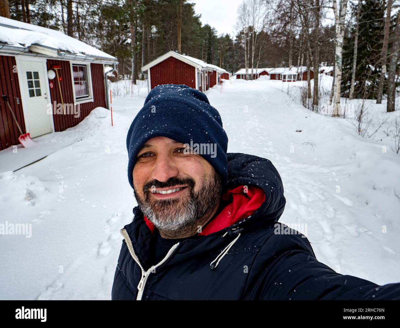 Pov of a man in winter clothes taking a smiling selfie in a snowy landscape in Sweden. Winter ...