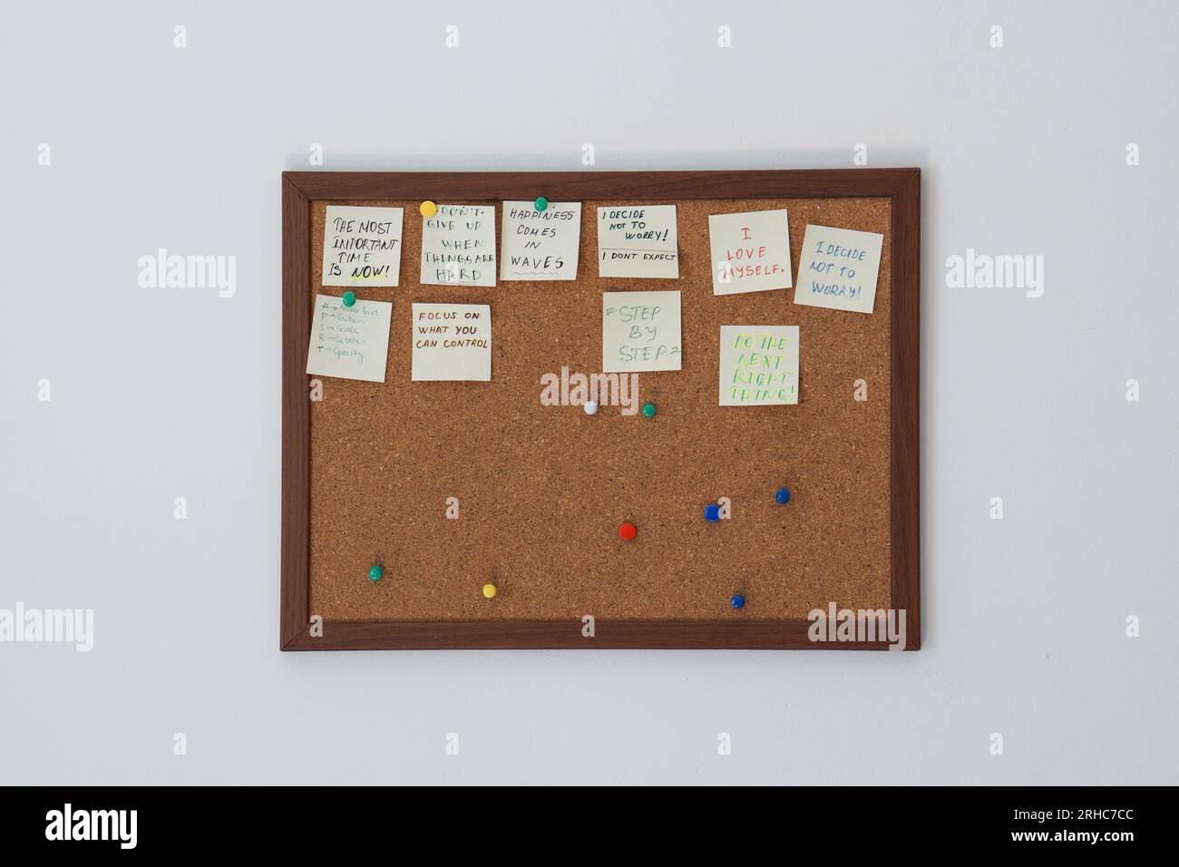Cork board with stick notes with motivational sentences on them on a ...