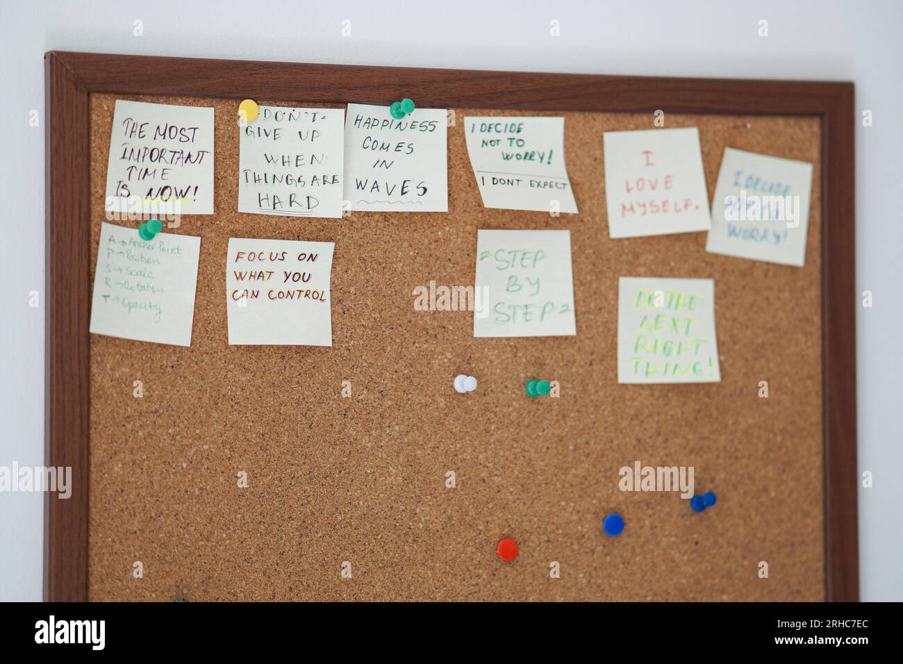 Cork board with stick notes with motivational sentences on them on a ...