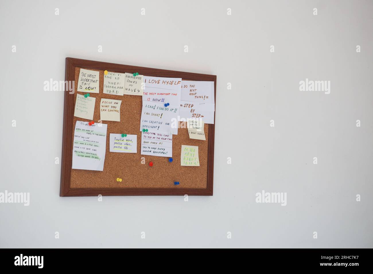 Cork board with stick notes with motivational sentences on them on a ...