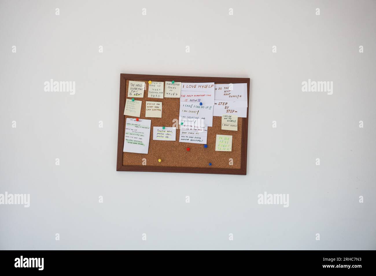 Cork board with stick notes with motivational sentences on them on a ...