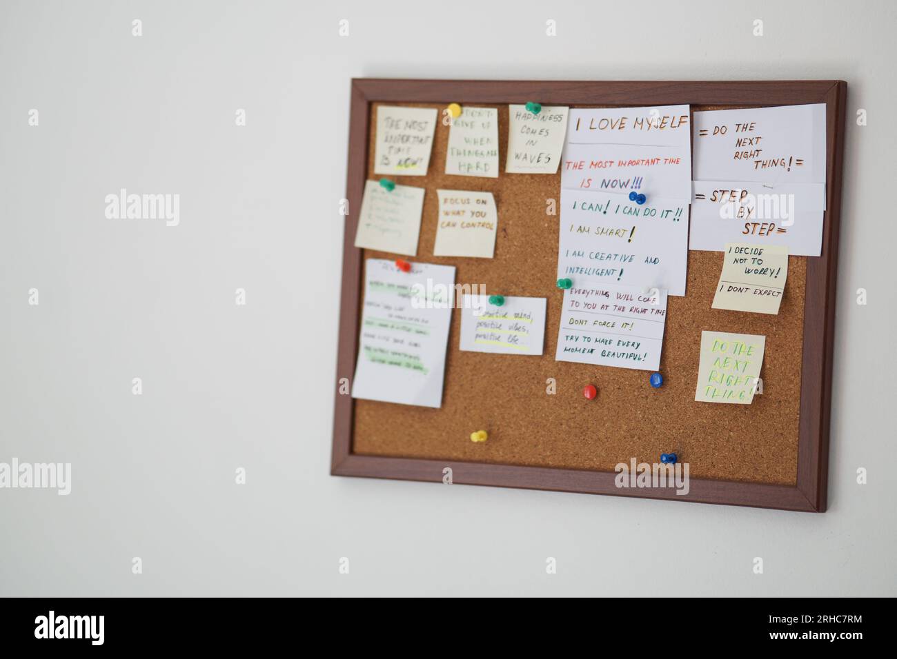 Cork board with stick notes with motivational sentences on them on a ...