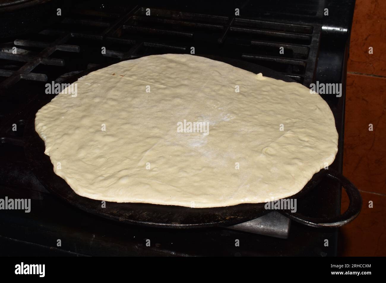 Sada roti being cooked on a tawa, a kitchen utensil which is made from ...