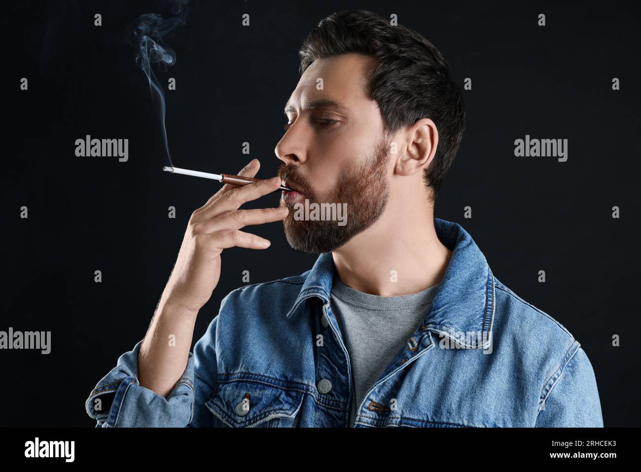 Man using cigarette holder for smoking on black background Stock Photo ...