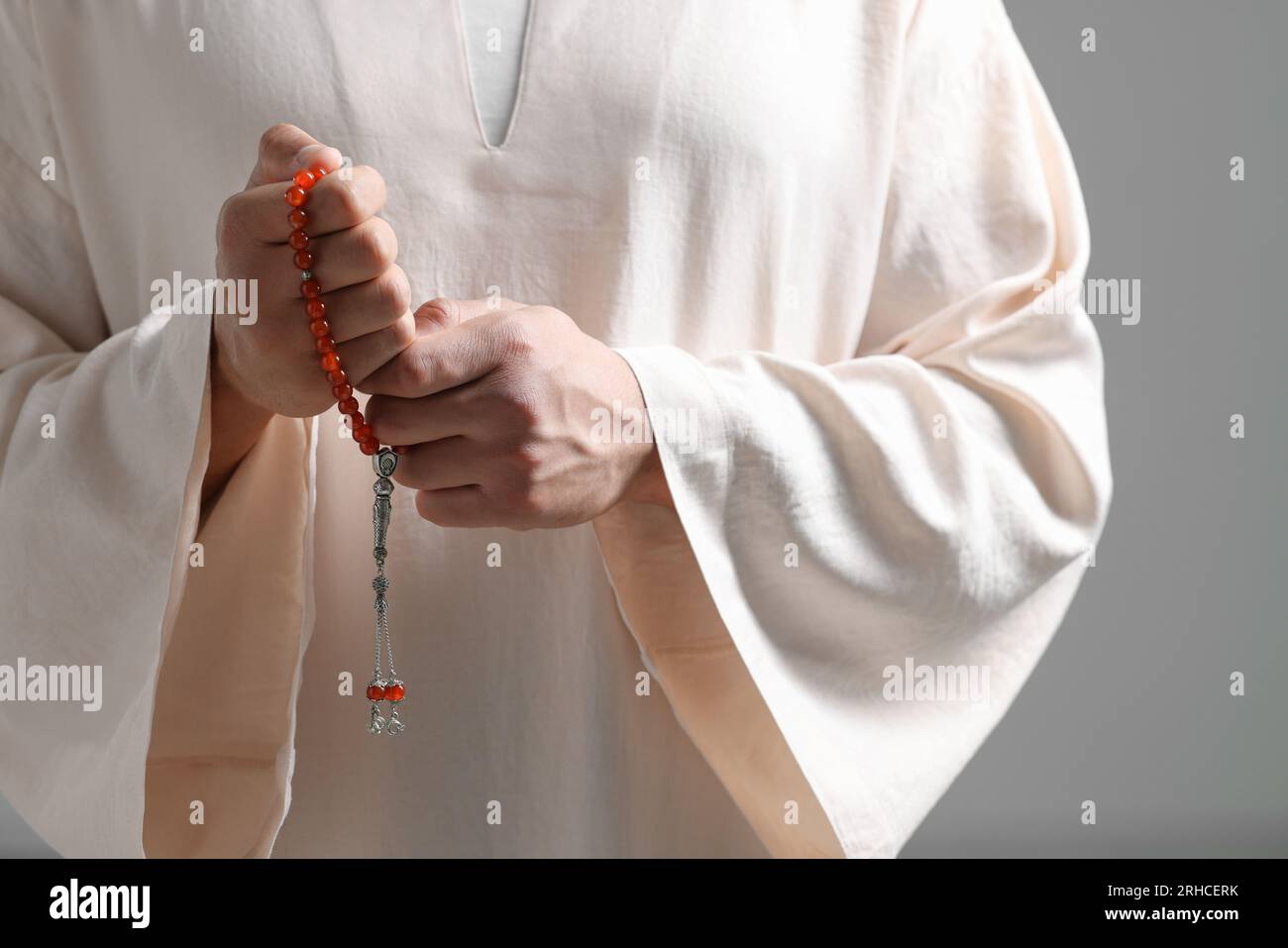 Muslim man with misbaha on light grey background, closeup Stock Photo ...