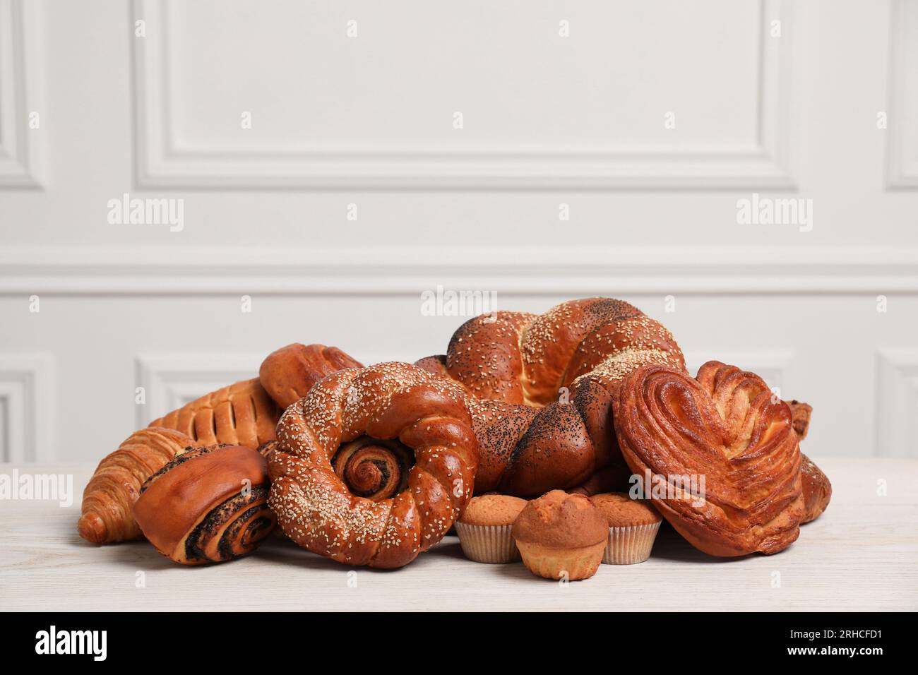 Different tasty freshly baked pastries on white wooden table, space for ...