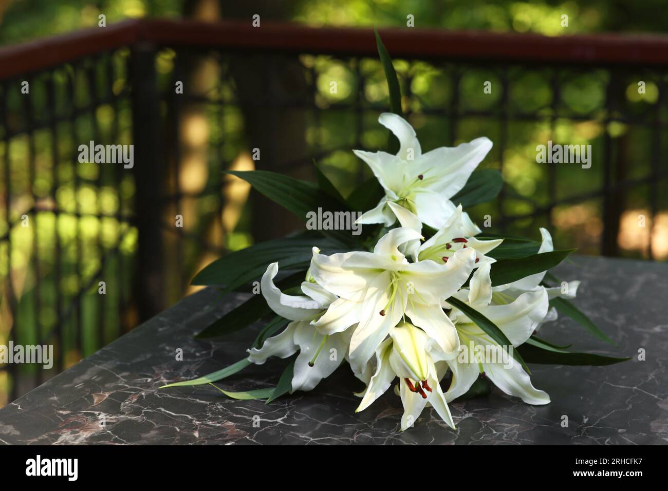 White lilies on tombstone at cemetery outdoors. Funeral ceremony Stock ...