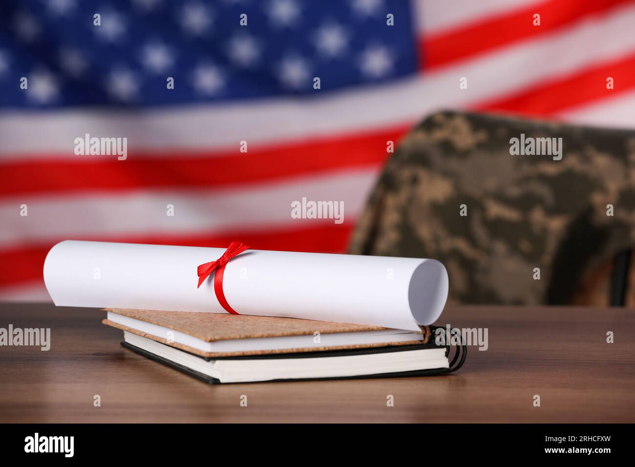 Diploma and notebooks on wooden table against flag of USA. Military ...