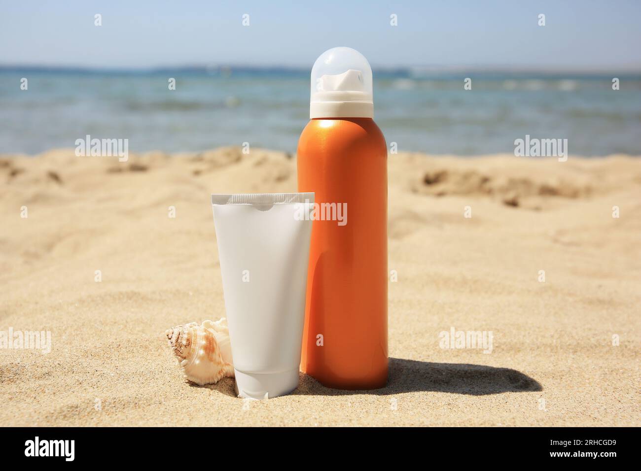 Sunscreens and seashell on sandy beach. Sun protection care Stock Photo ...