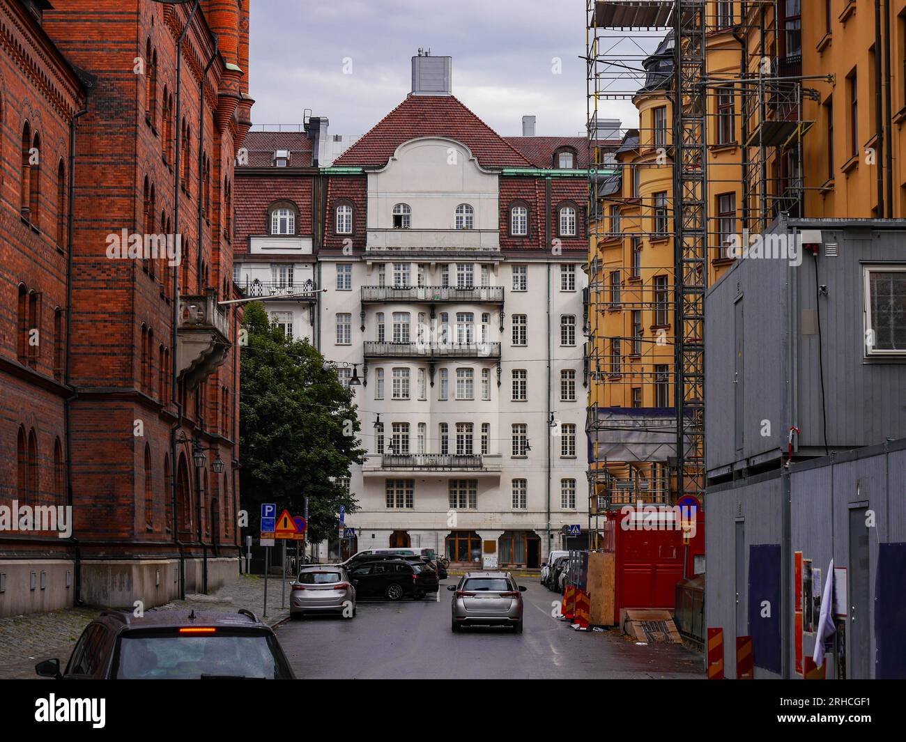 a narrow city street with cars parked on the side Stock Photo - Alamy
