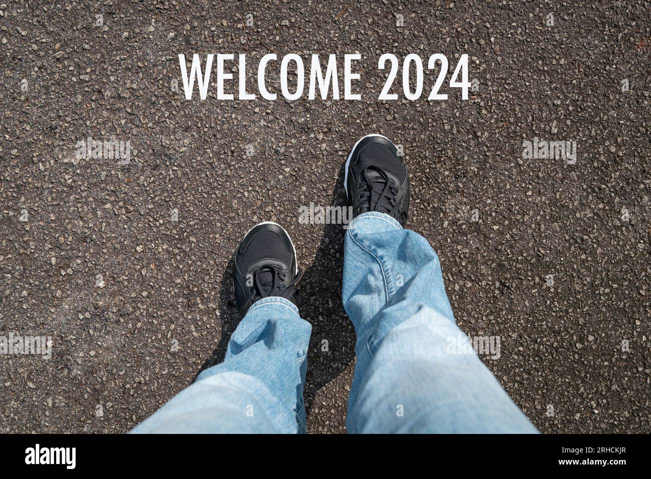 Welcome 2024, word on street in front of woman. Top view Stock Photo ...