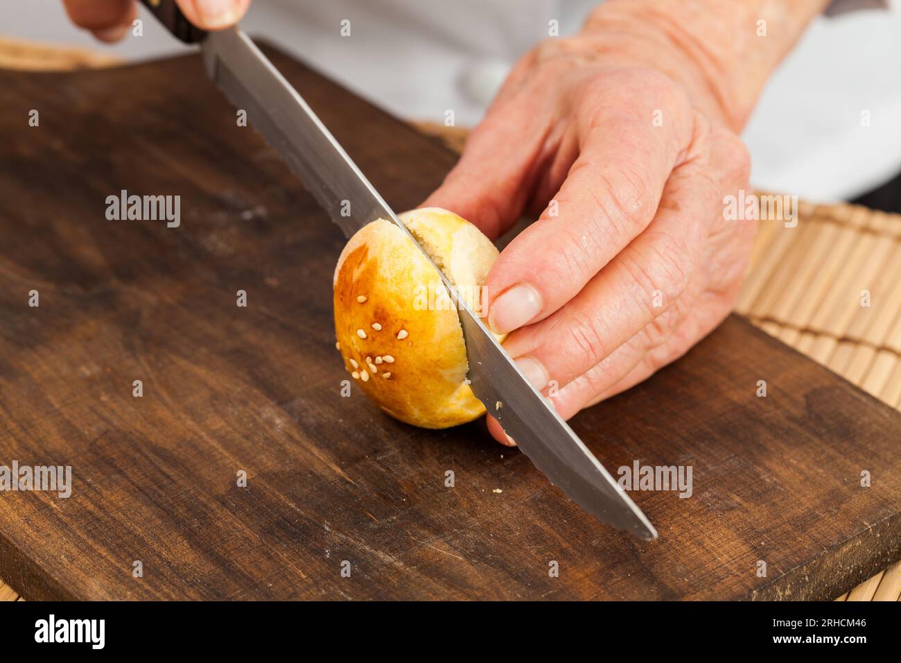Cutting small bread buns for mini burgers. Step by step preparation of ...