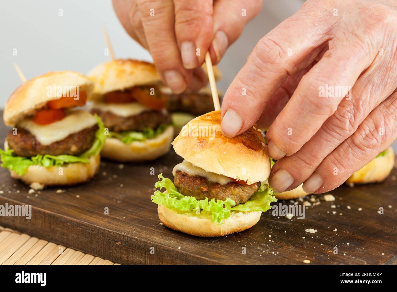 Putting on a toothpick on burger. Step by step preparation of mini ...
