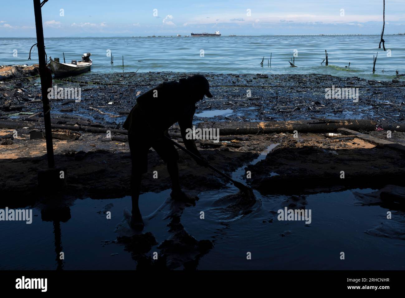 A man shovels away invading polluted water from the inside of a ...