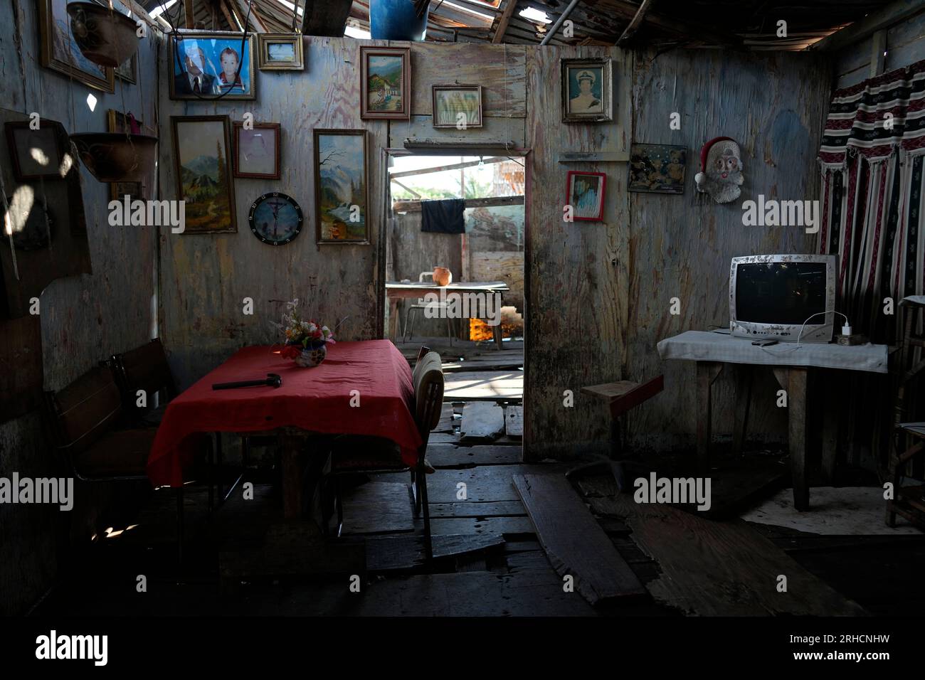 Family portraits and paintings adorn the walls of a stilt home that ...