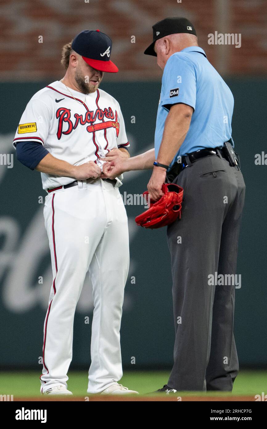 Umpire Jeff Nelson examines Atlanta Brave relief pitcher A.J. Minter ...