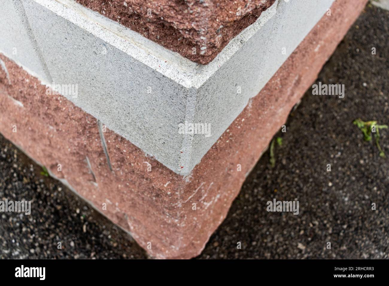 White painted concrete corner with grass - chipped and rough texture ...
