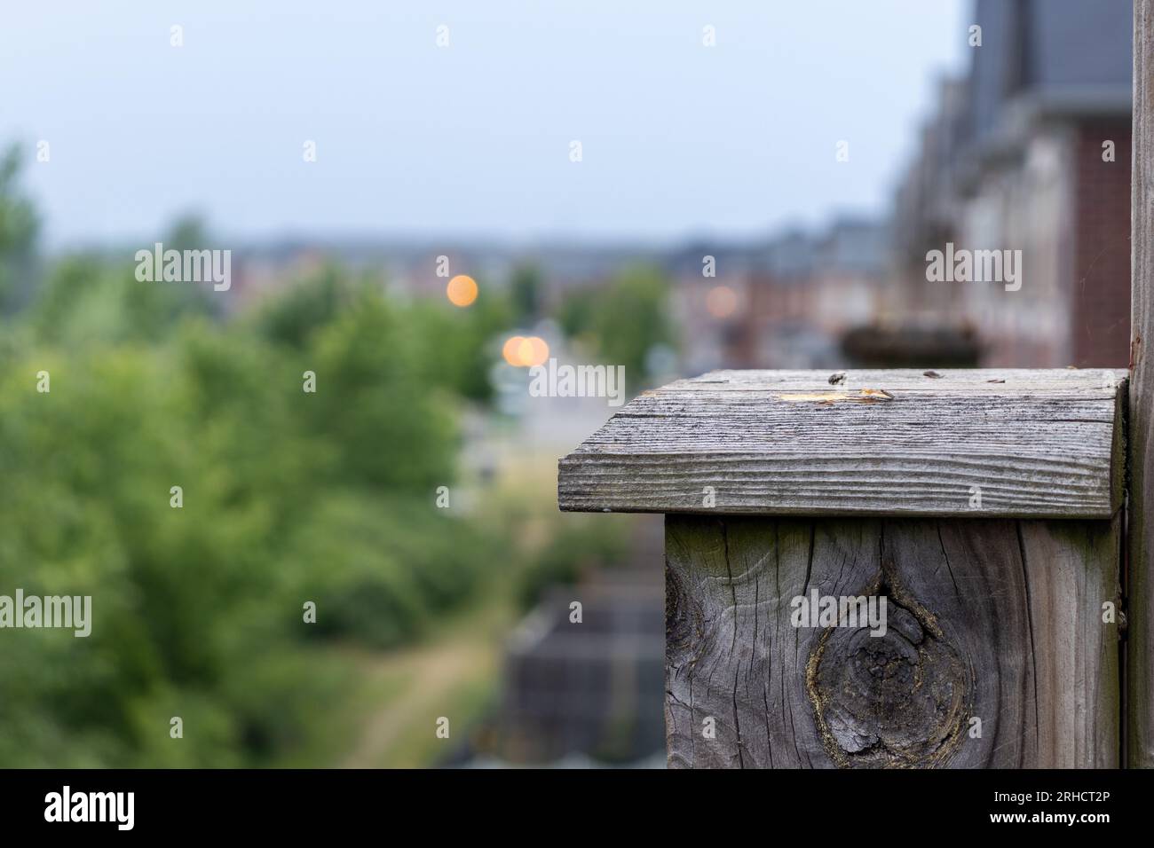 Wooden fence post with knot - suburban neighborhood in background ...