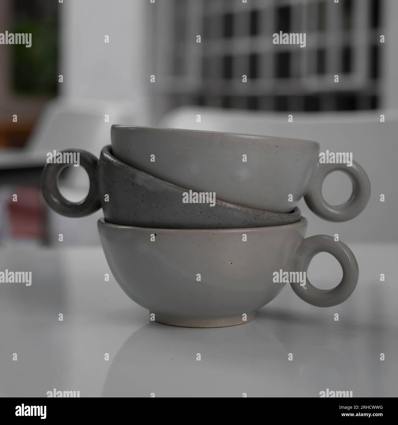 Arranged ceramic cups, gray white background with a clean shiny table ...
