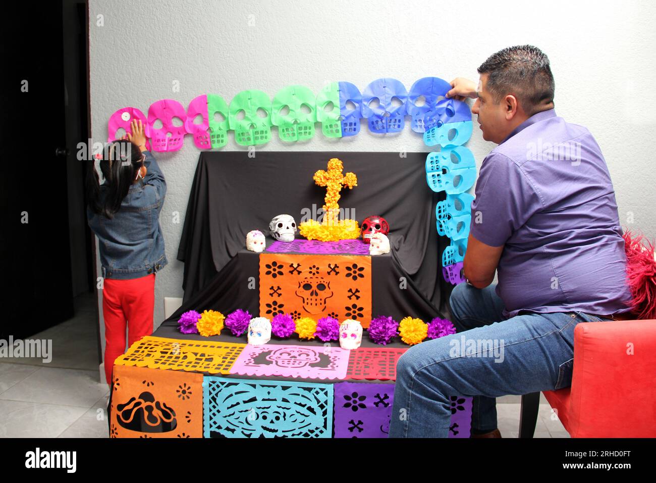 Mexican dad and daughter put the altar and offering of the Day of the ...