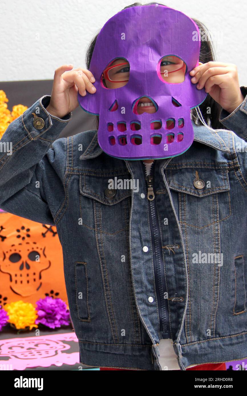 Mexican child girl put the altar and offering of the Day of the Dead in ...