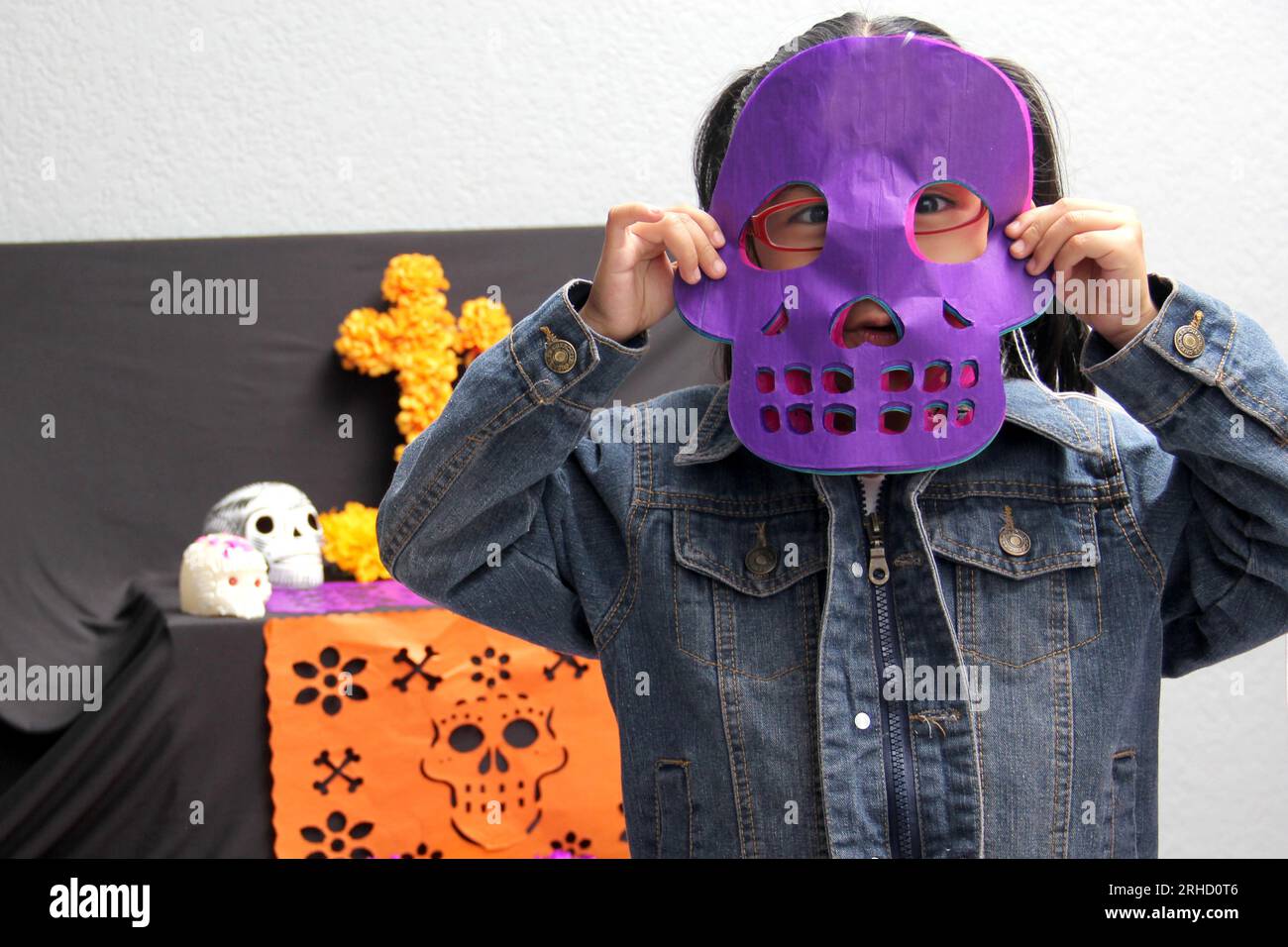 Mexican child girl put the altar and offering of the Day of the Dead in ...
