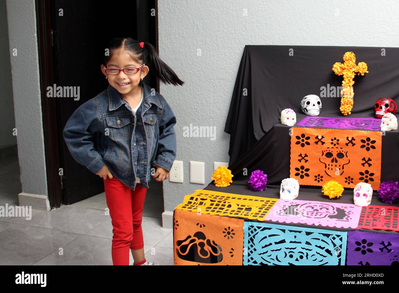Mexican child girl put the altar and offering of the Day of the Dead in ...