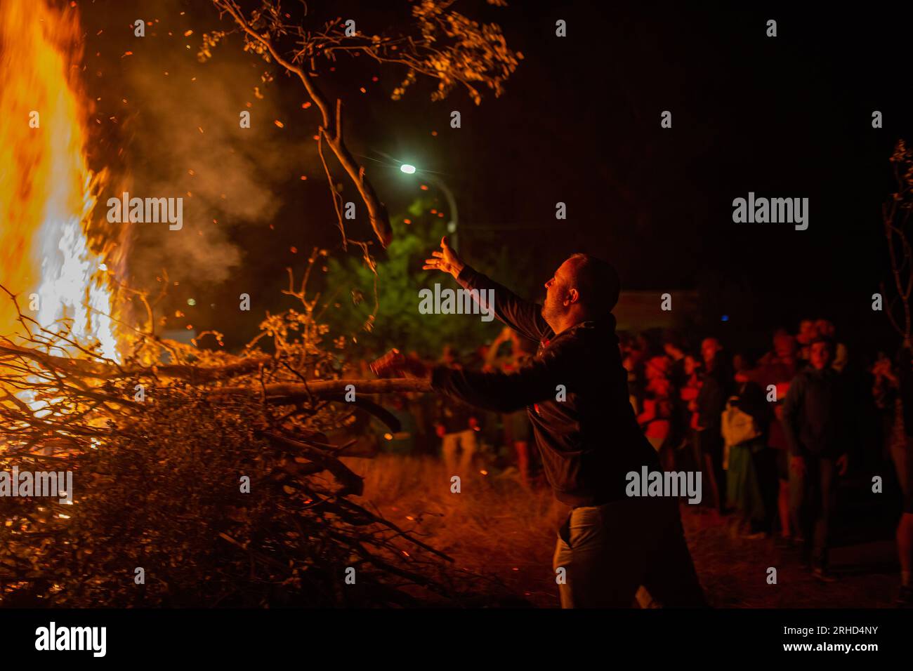 A man throws an oak branch into the fire, during the celebration of the ...