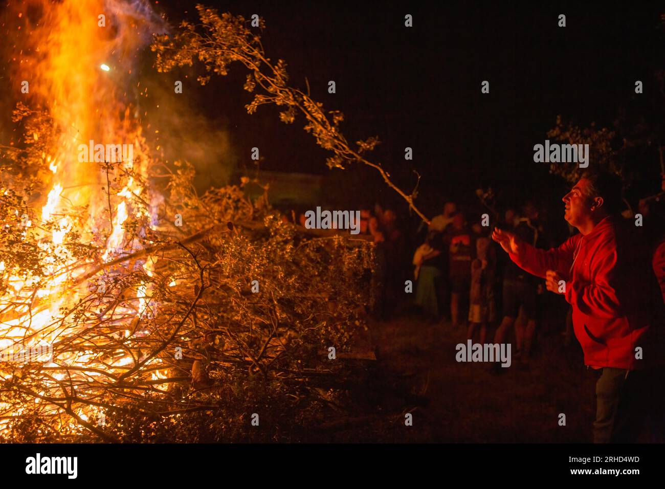 A man throws an oak branch into the fire, during the celebration of the ...