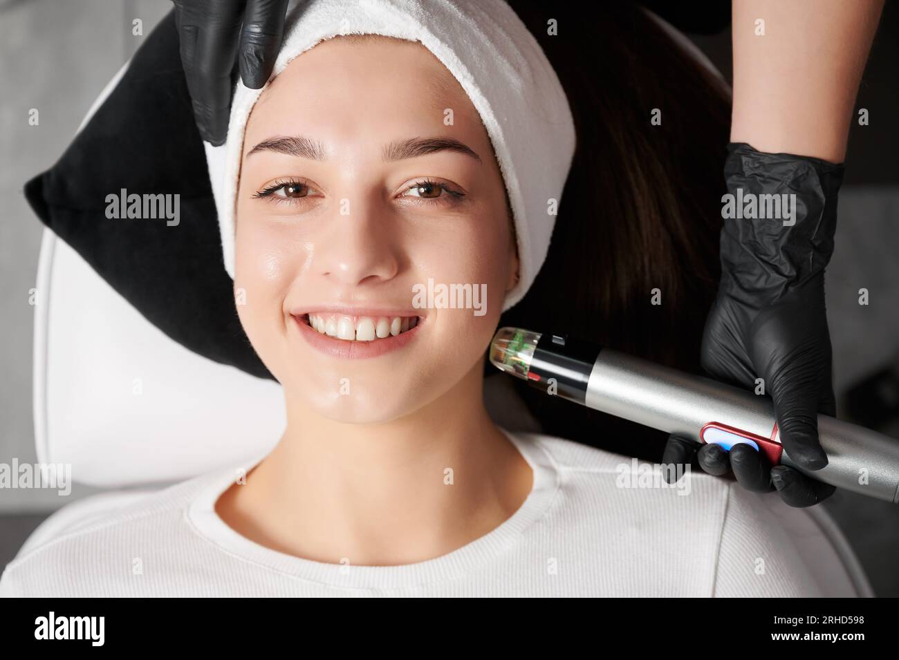 Top view of medical esthetician using radiofrequency device while ...