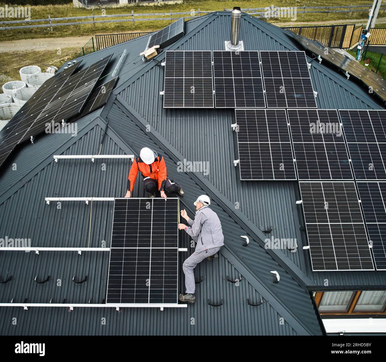 Workers measuring photovoltaic solar panels with tape measure. Men ...
