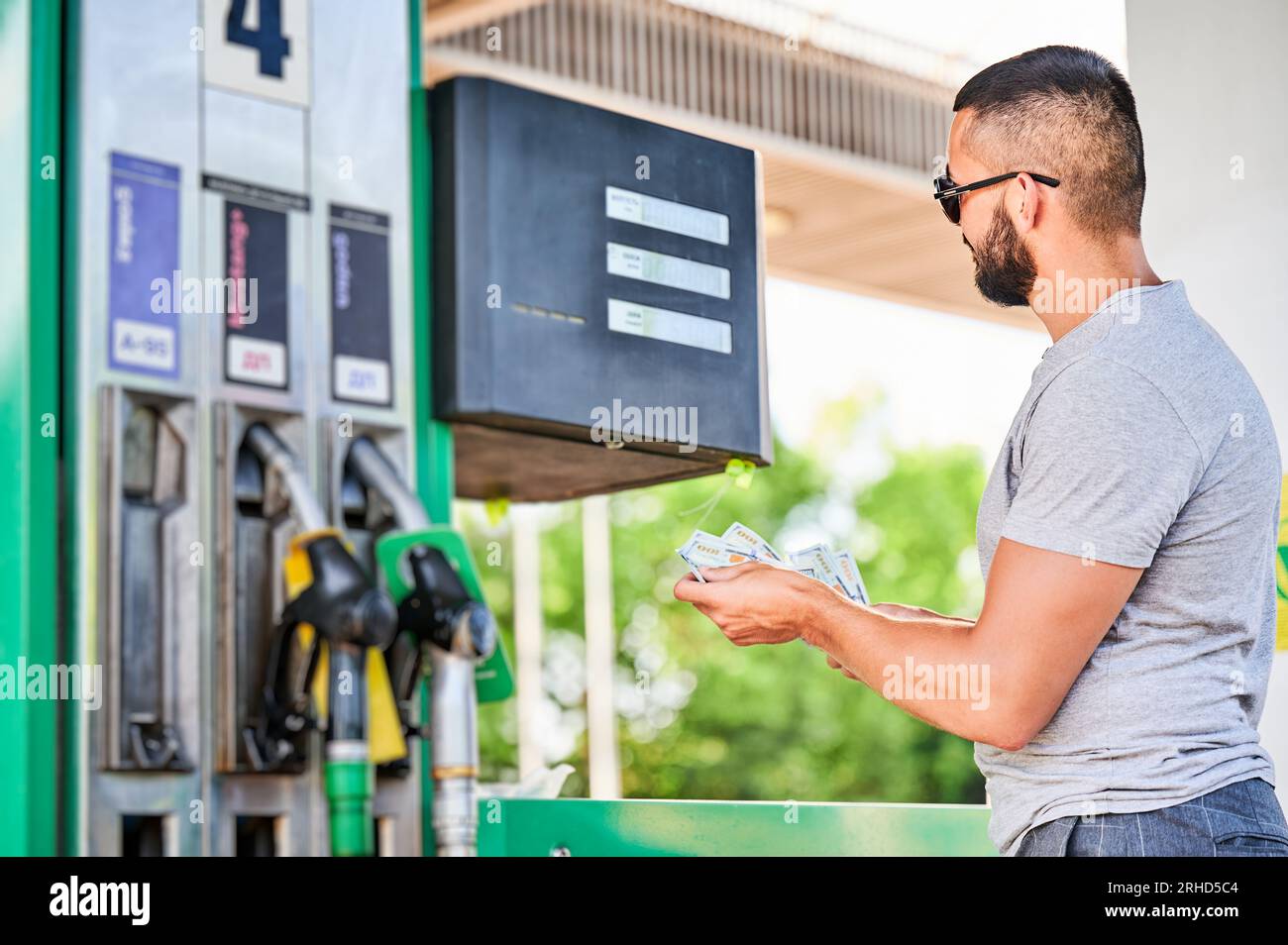 Worried man shocked how much gasoline costs. Driver counting if he has ...