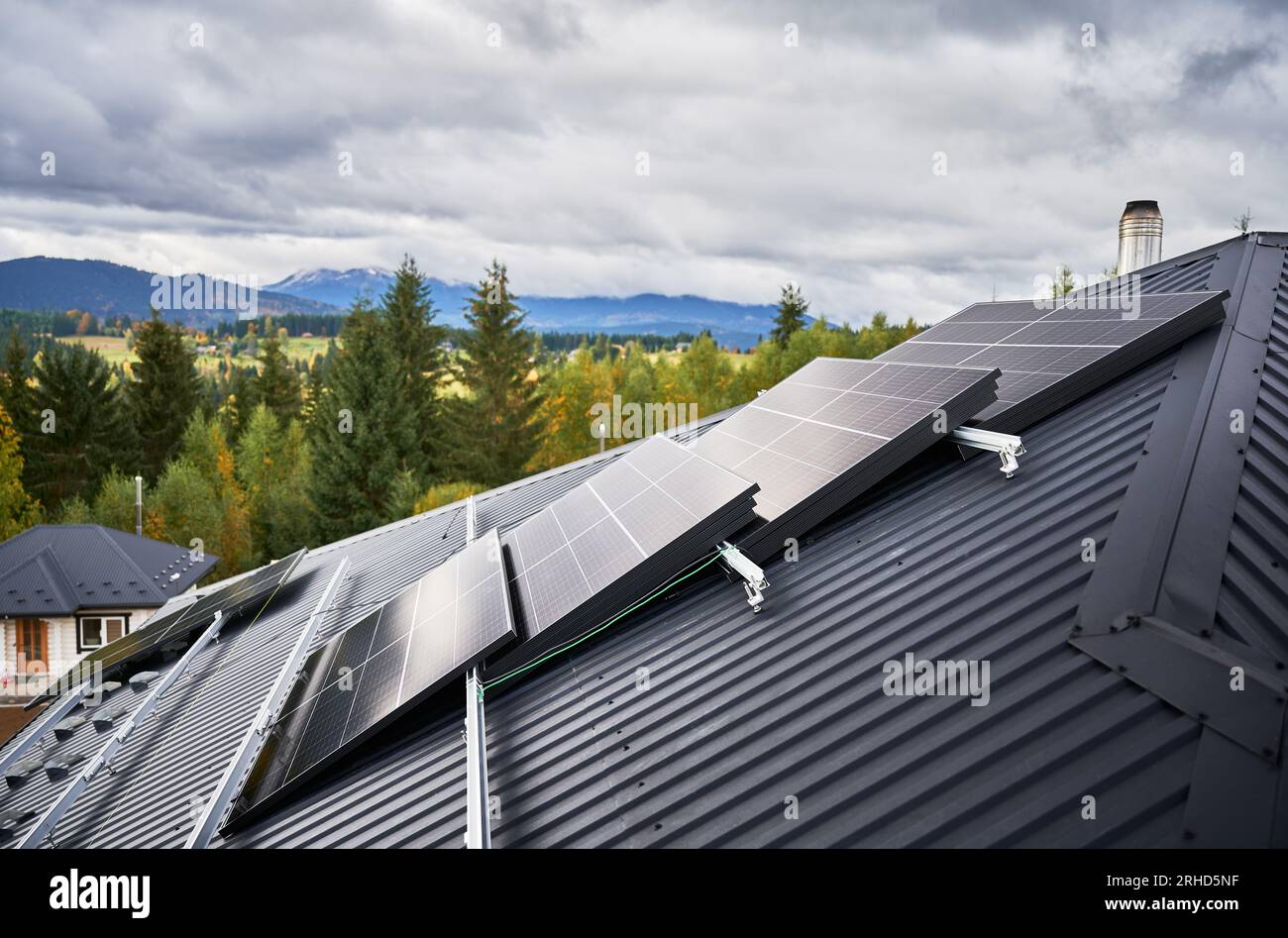 Solar photovoltaic panels on a roof of house. Dark blue solar cells ...