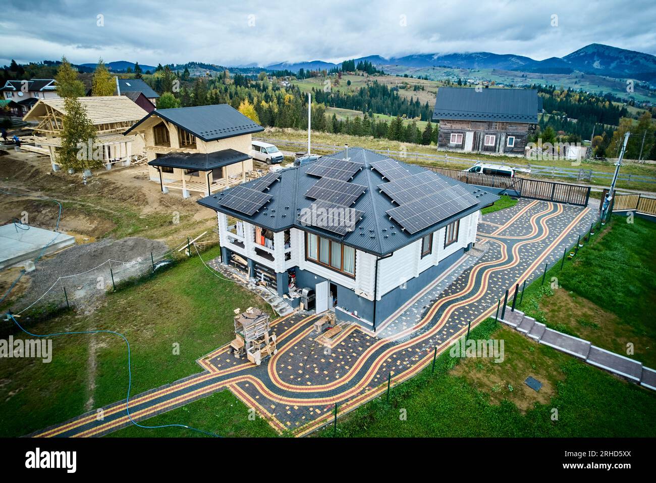 Aerial view of new modern house cottage in the mountains with solar photovoltaic panel system on ...