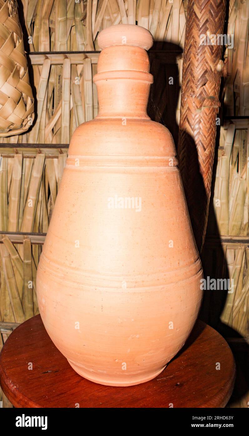 A bulging earthenware container for storing water, with a short, narrow ...