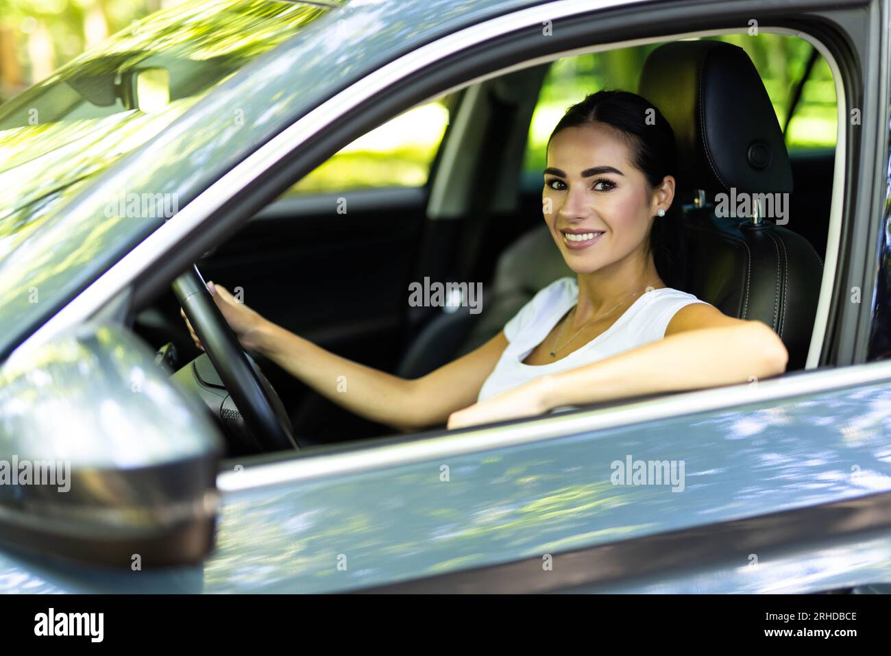 Mother driving a car with family on a road trip hi-res stock ...