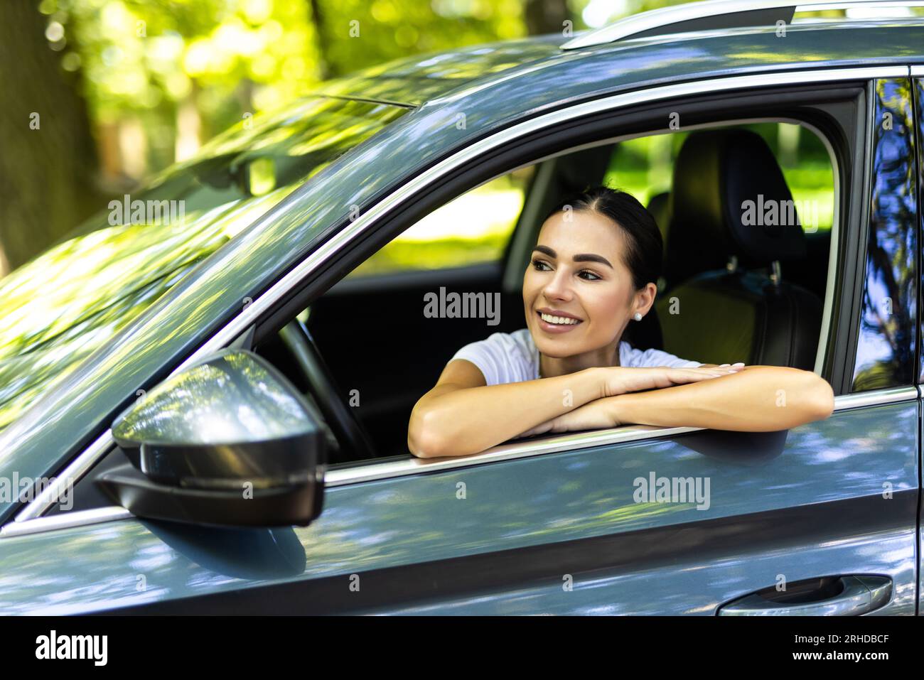 Mother driving a car with family on a road trip hi-res stock ...