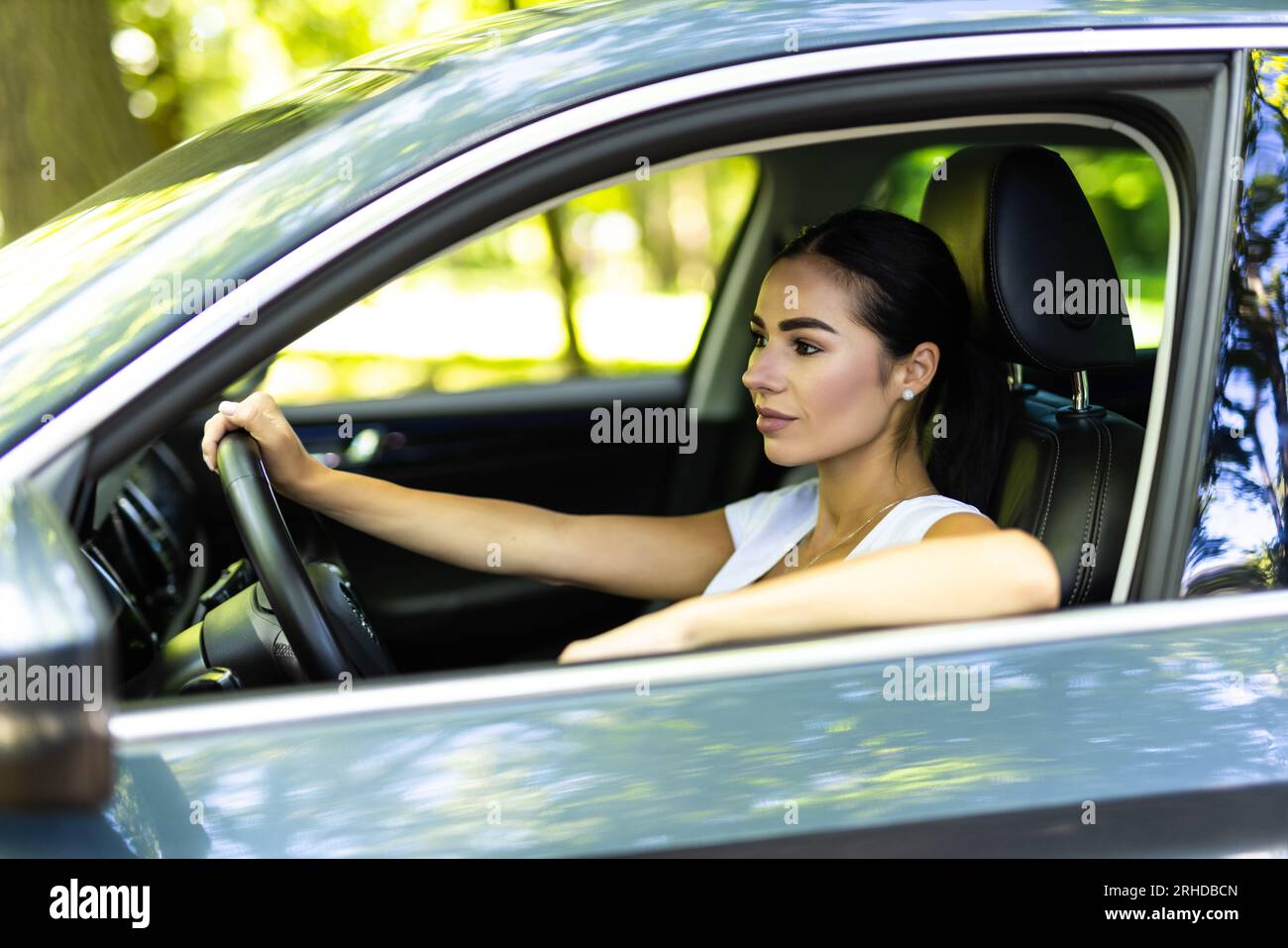 Mother driving a car with family on a road trip hi-res stock ...