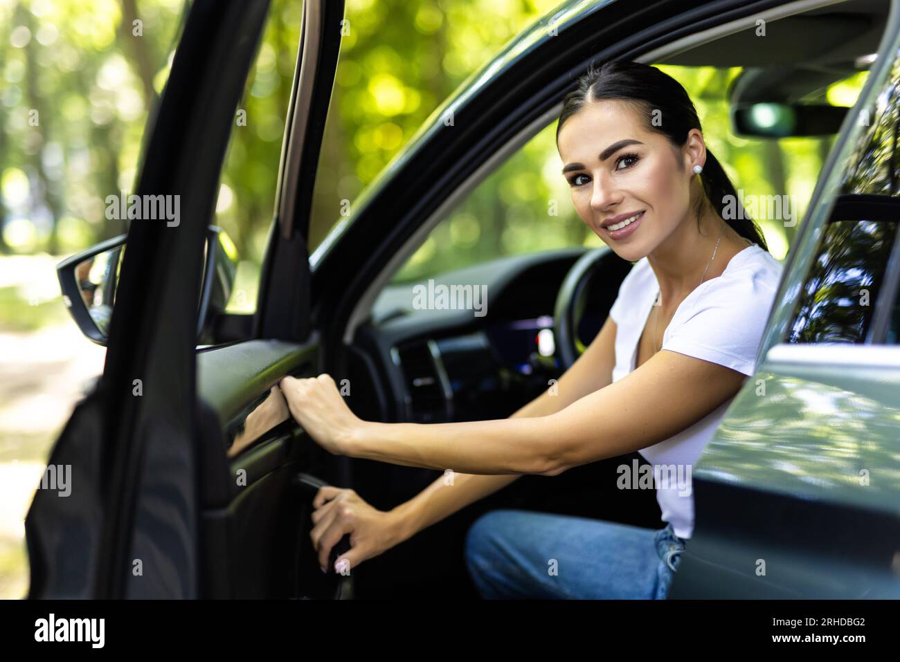 Young woman getting out of car Stock Photo - Alamy