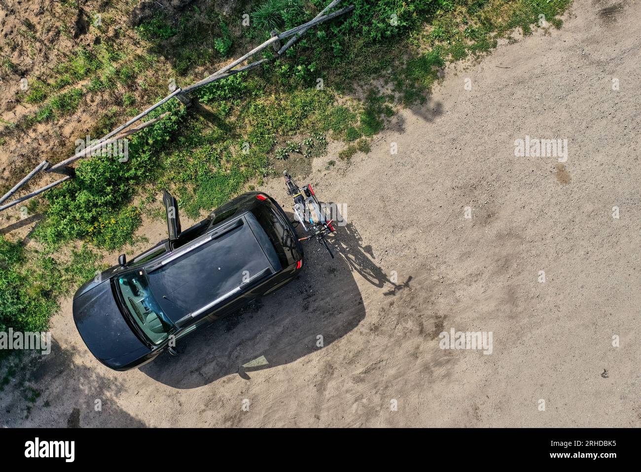 Aerial view of a black SUV with a bike rack in a gravel parking lot ...