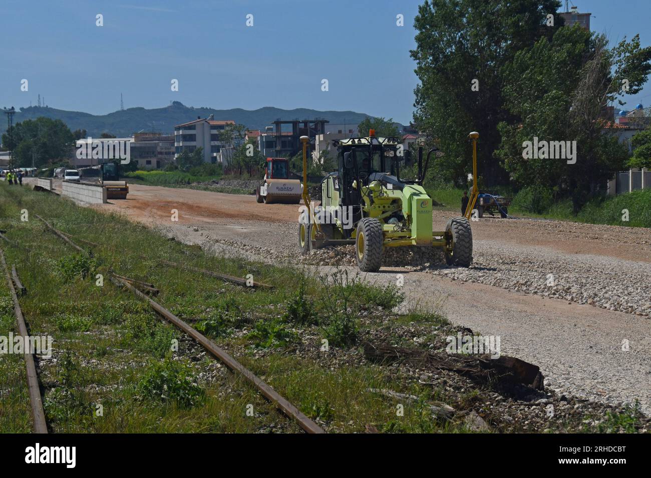 Grader and roller levelling and grading the base for the reconstruction ...