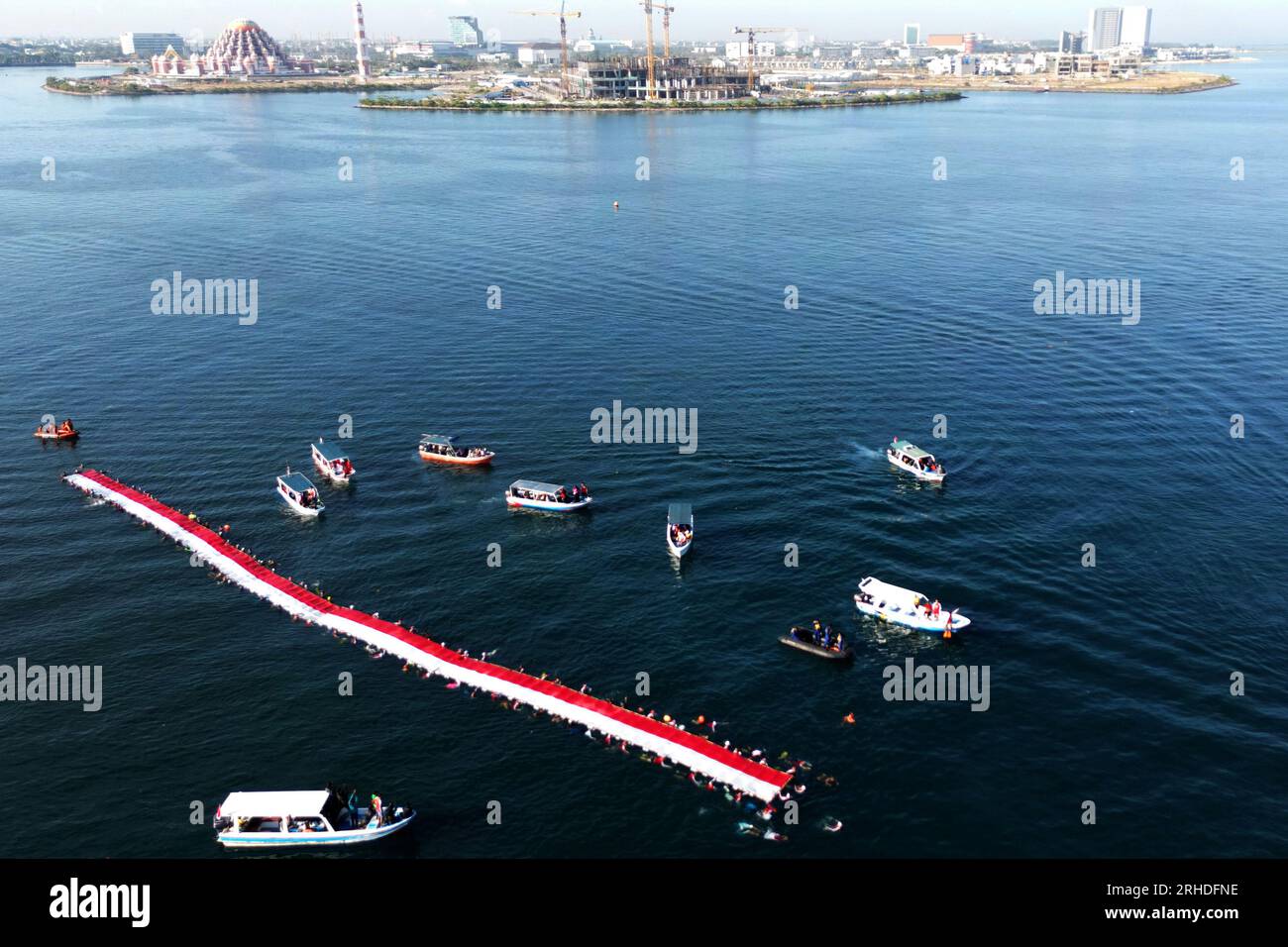Jakarta, Indonesia. 12th Aug, 2023. This aerial photo shows swimmers unfolding a 78-meter long ...
