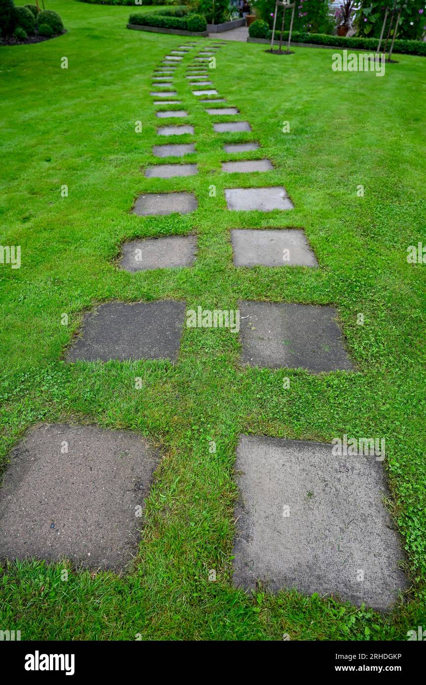 concrete slabs in lawn making a walk path Stock Photo - Alamy