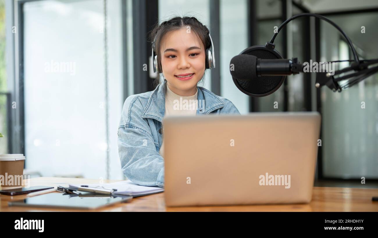 An attractive Asian female radio host or content creator is looking at ...