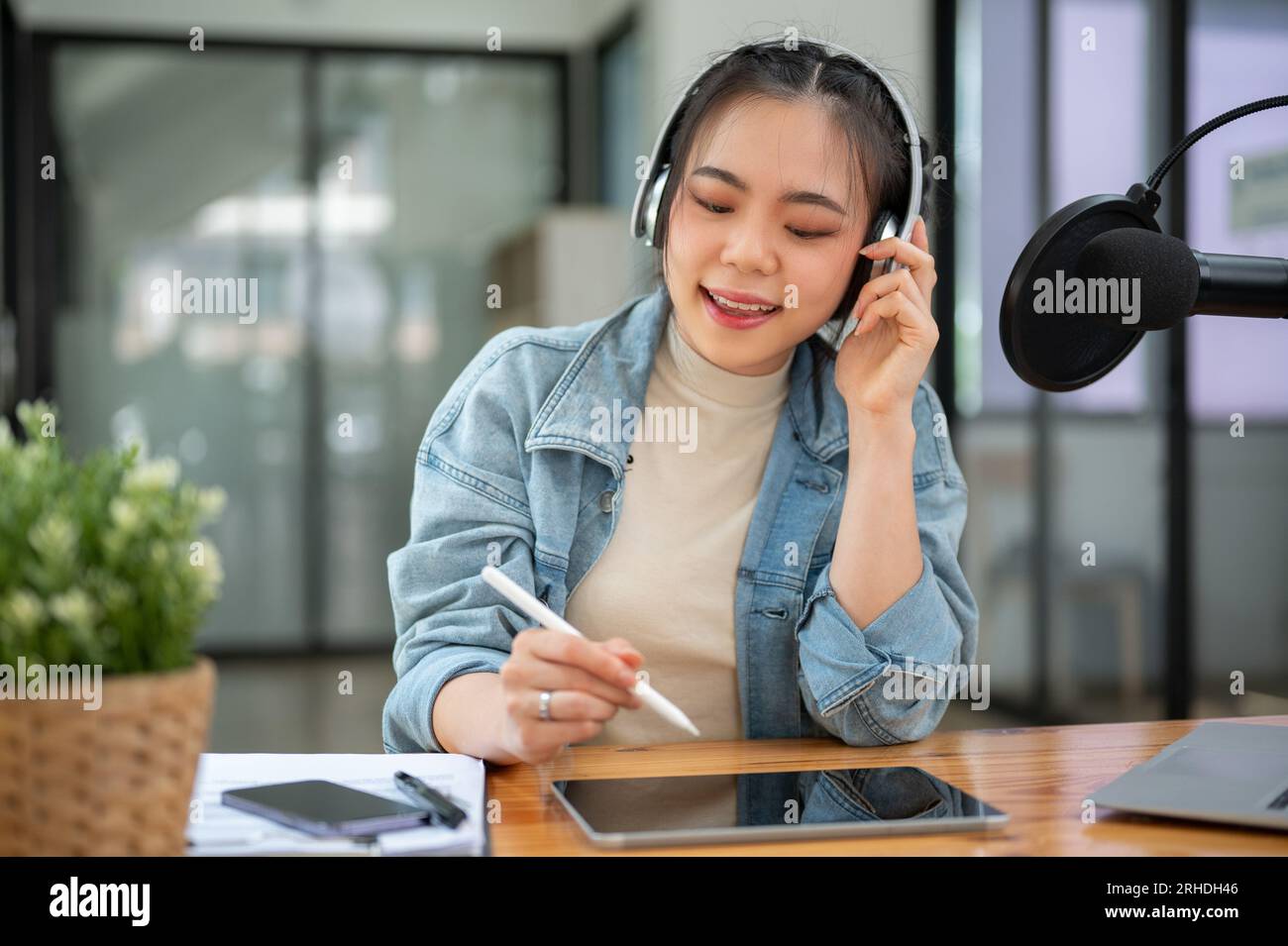 A happy and charming Asian female radio host is interviewing a guest ...