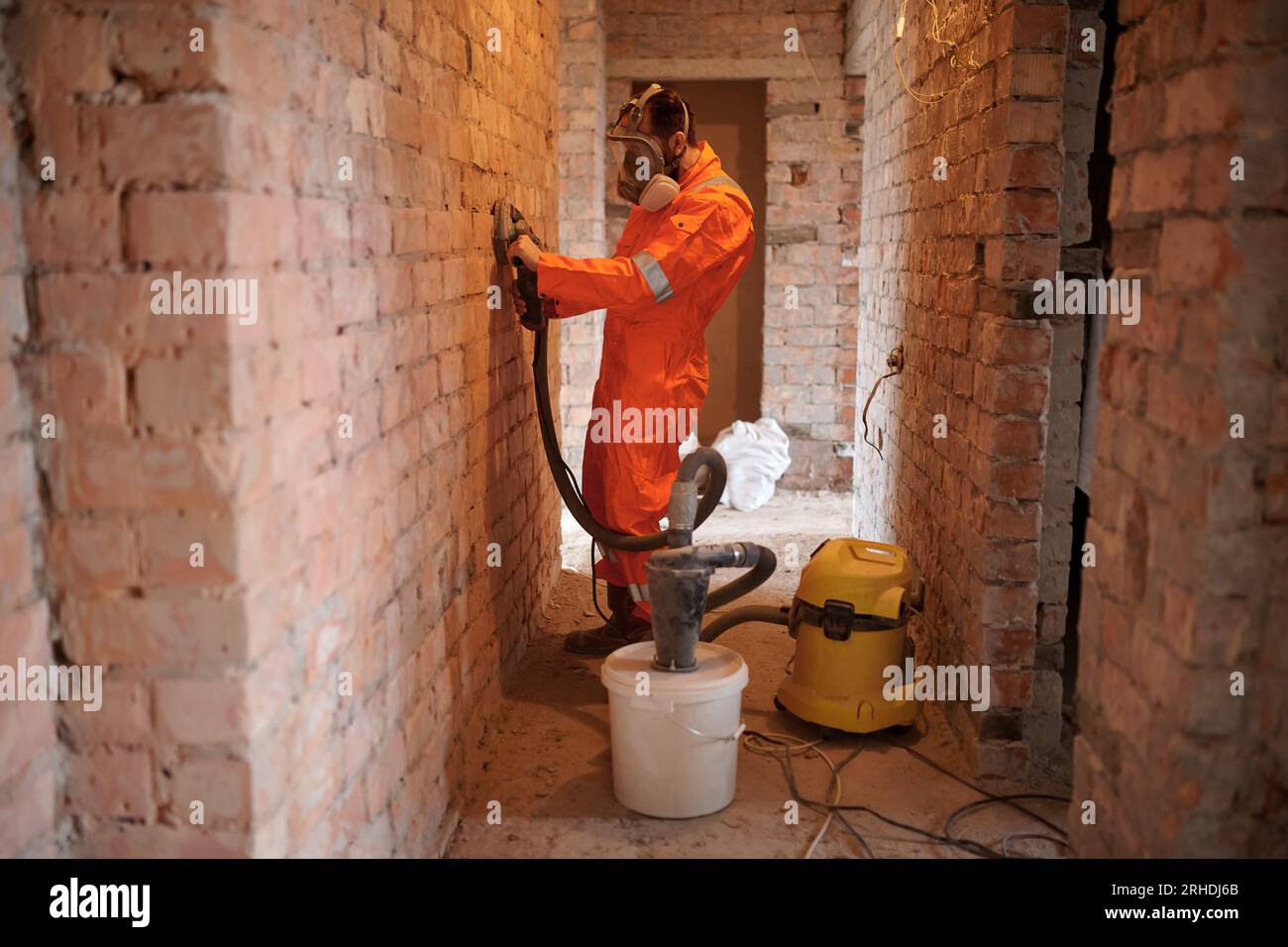 Construction worker grinding brick wall using grinding machine with ...