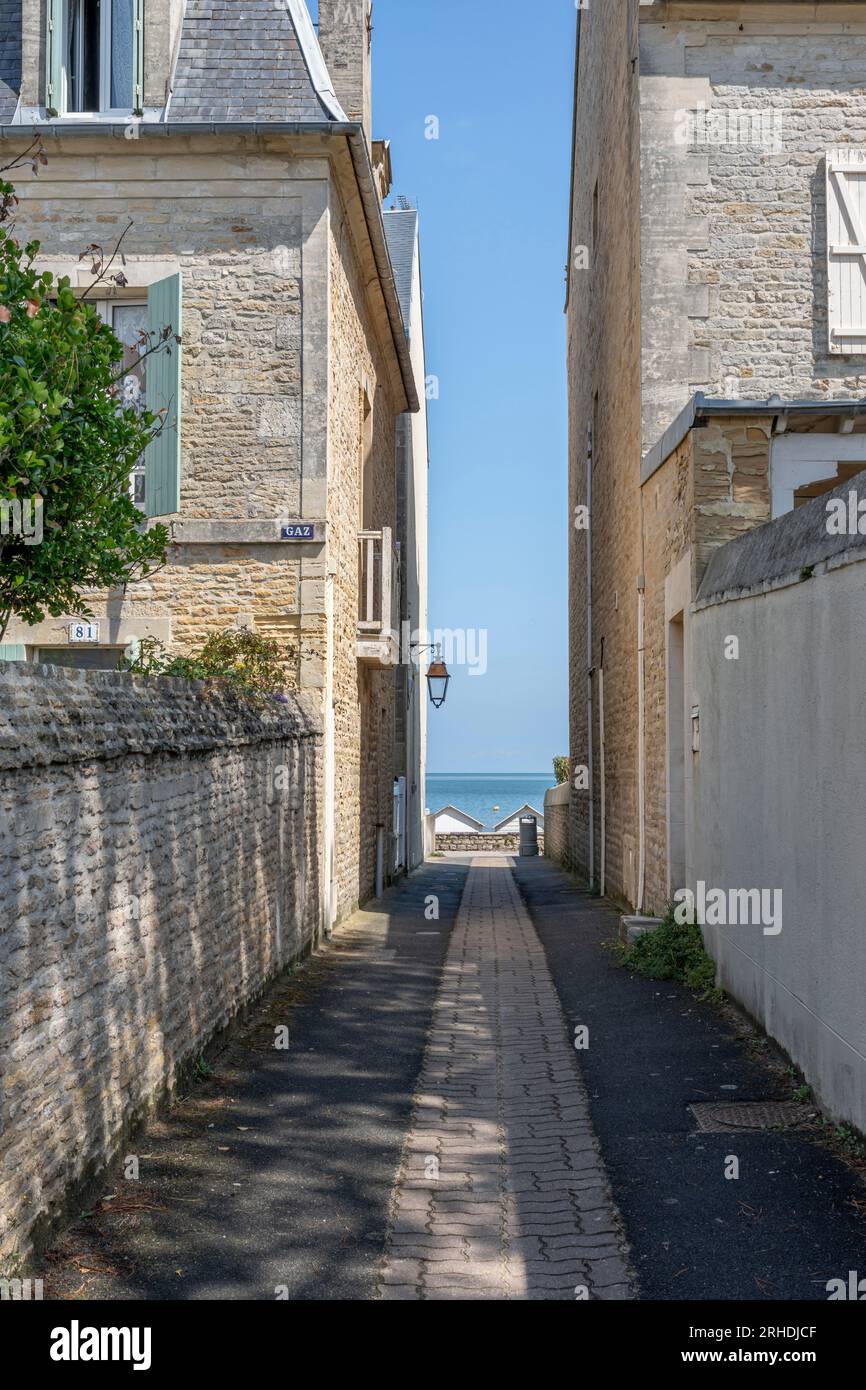 View from a tiny street of the beach, the sea and houses Stock Photo ...