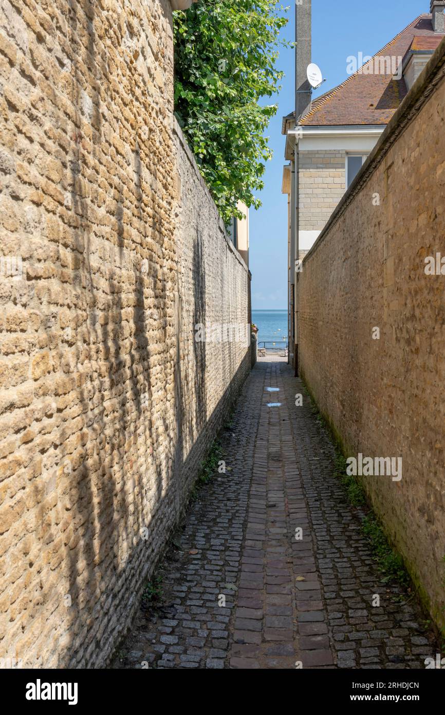 View from a tiny street of the beach, the sea and houses Stock Photo ...