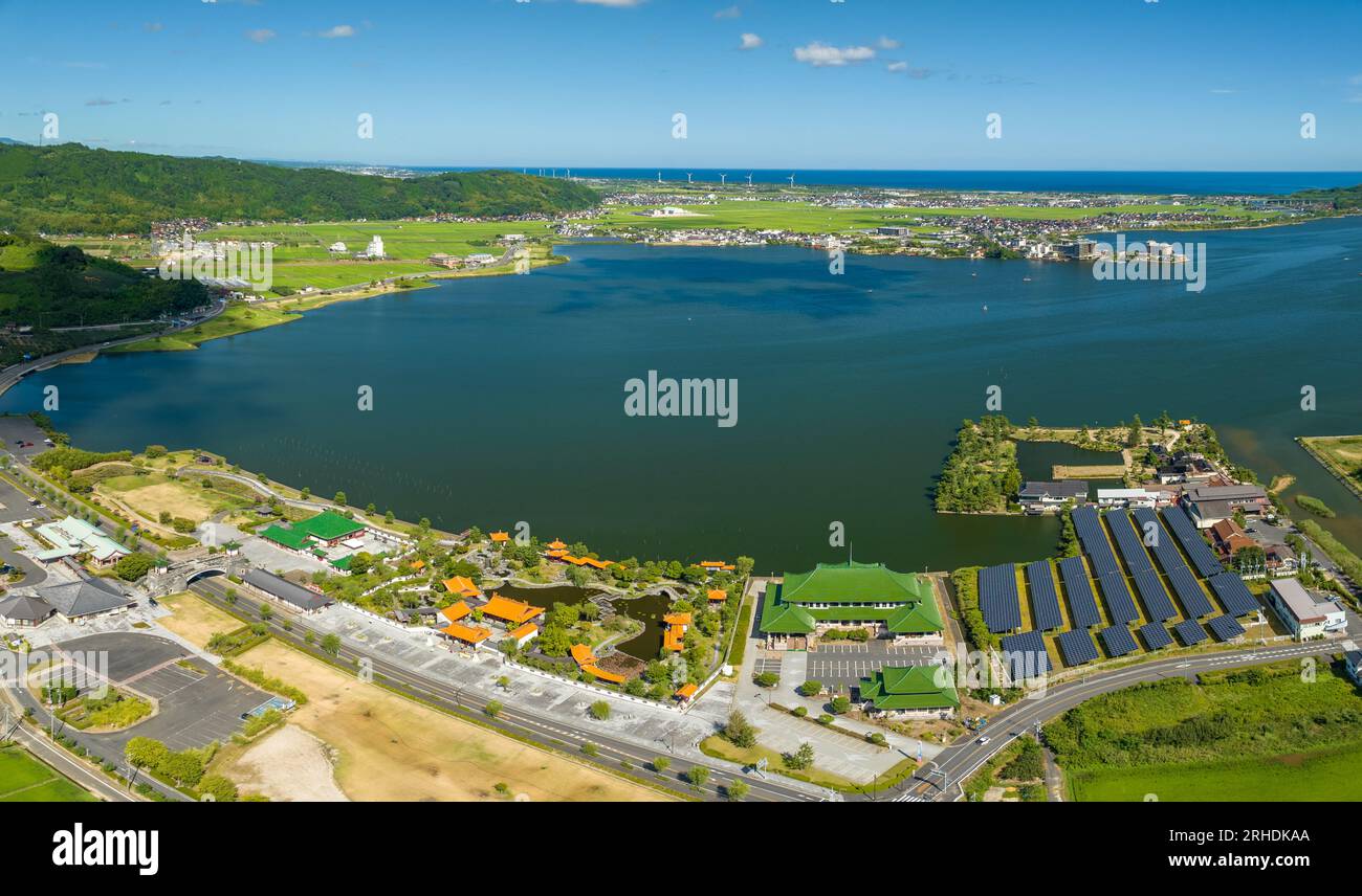 Aerial view of traditional Japanese buildings and solar panels by lake ...