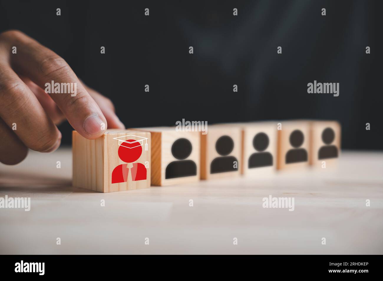 Hand reaching for red human icon on wooden block Stock Photo - Alamy